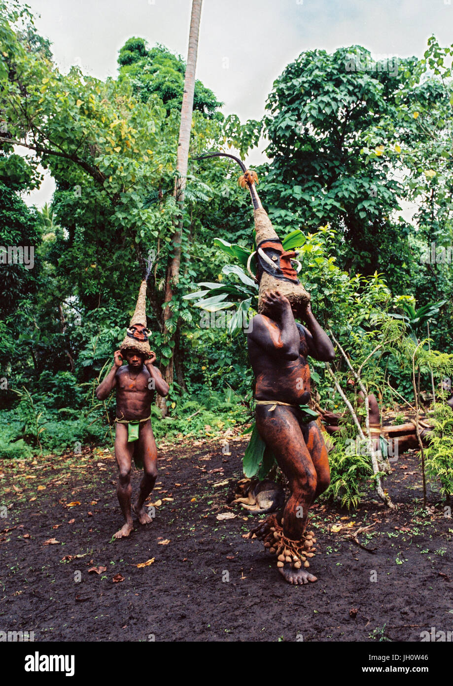 Tribesmen dancing in the jungle with helmet masks for a circumcision ...