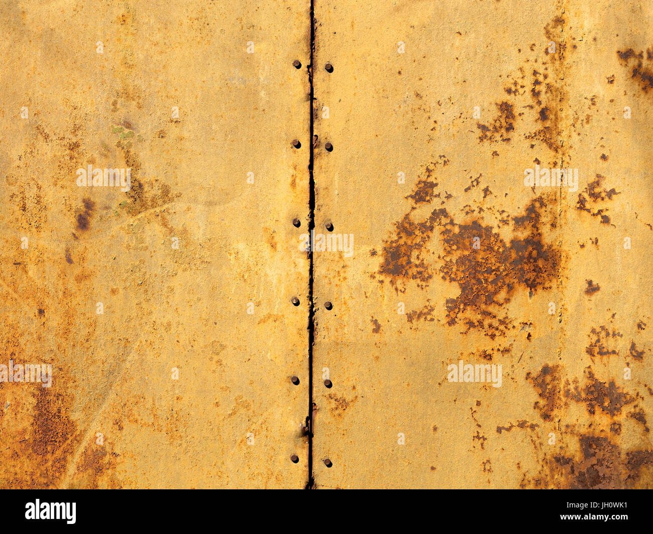 Two old metal sheets with a rust texture are connected together by ...
