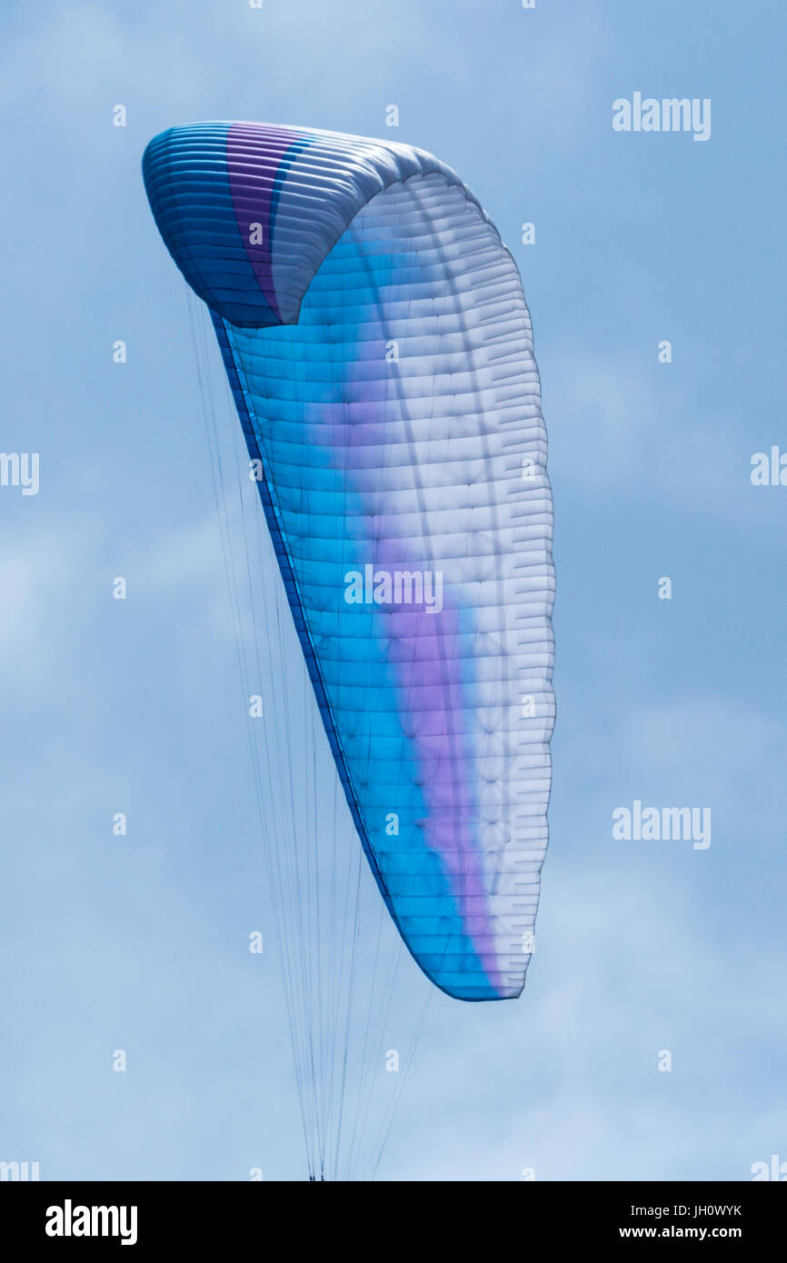 blue open parachute flying in blue sky Stock Photo - Alamy
