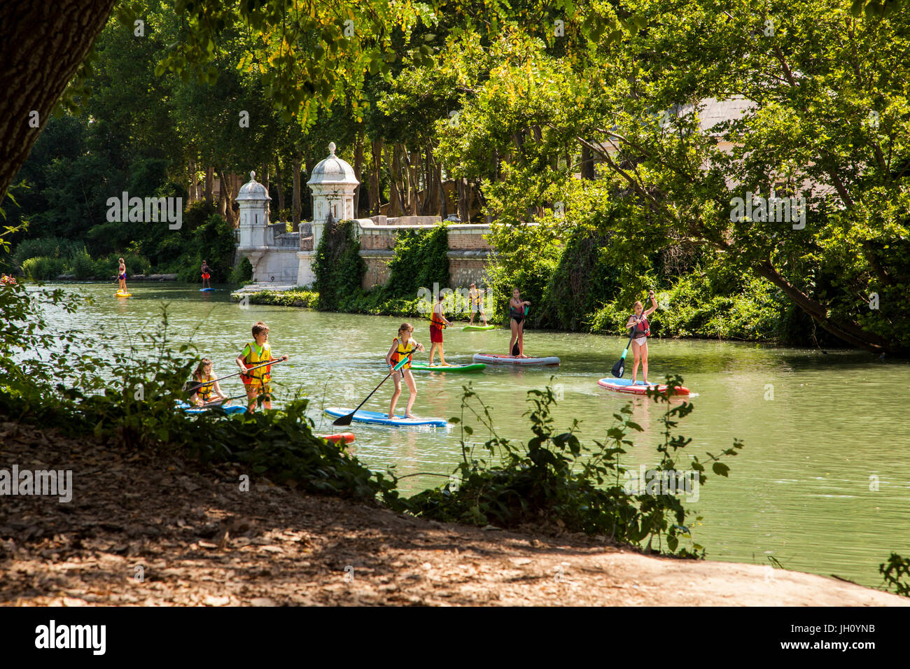 Children learning stand up paddle boarding on the River Tagus as it ...