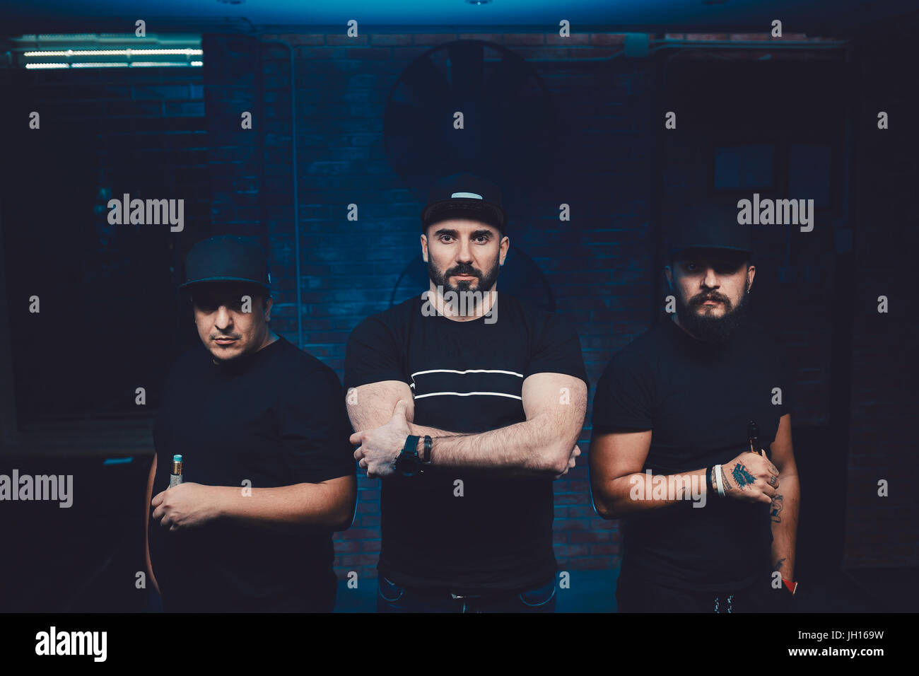 Three men vaping in an authentic room with brick walls. Vaping an ...