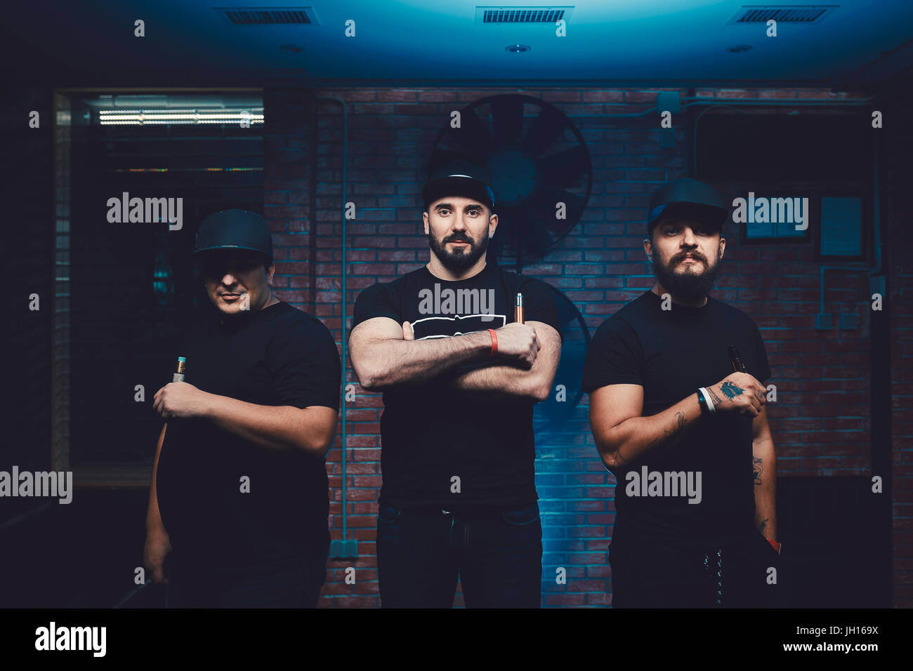 Three men vaping in an authentic room with brick walls. Vaping an ...