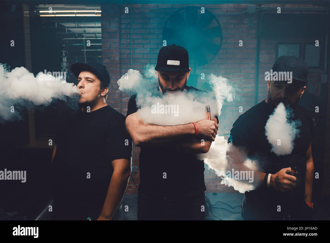 Three men vaping in an authentic room with brick walls. Vaping an ...