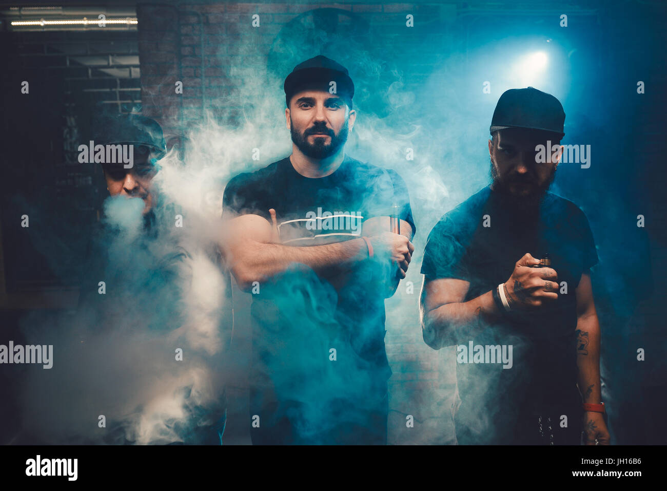 Three men vaping in an authentic room with brick walls. Vaping an ...
