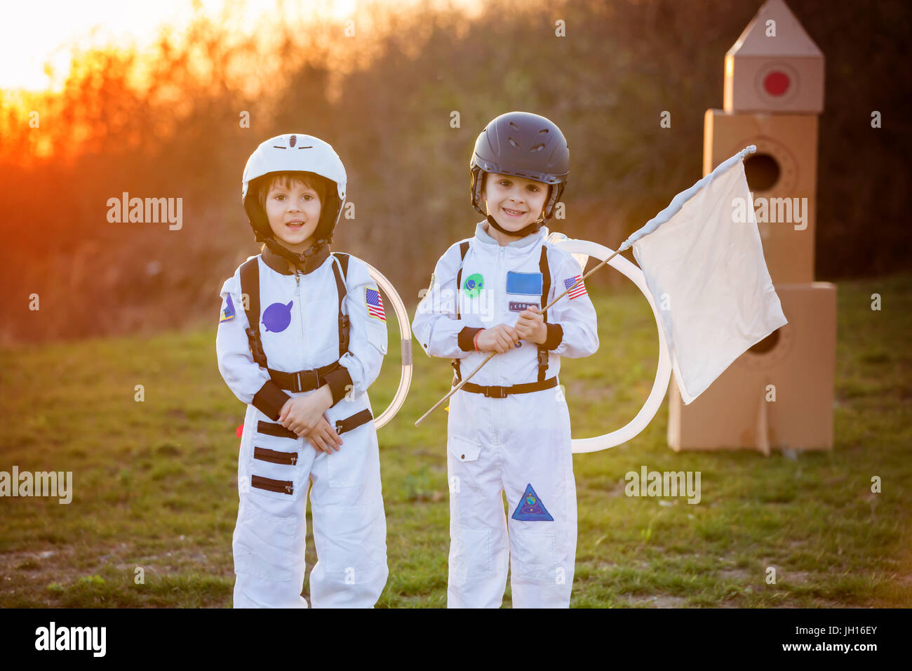 Two adorable children, boy brothers, playing in park on sunset, dressed ...