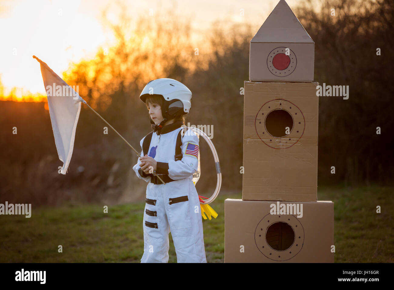 Adorable little boy, dressed as astronaut, playing in the park with ...
