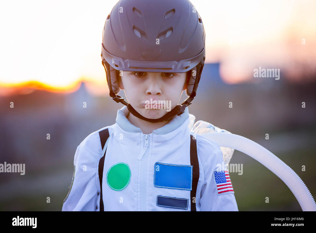 Adorable little boy, dressed as astronaut, playing in the park with ...