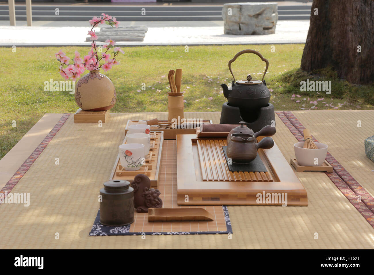 the japanese tea set under sakura tree in zen garden Stock Photo - Alamy