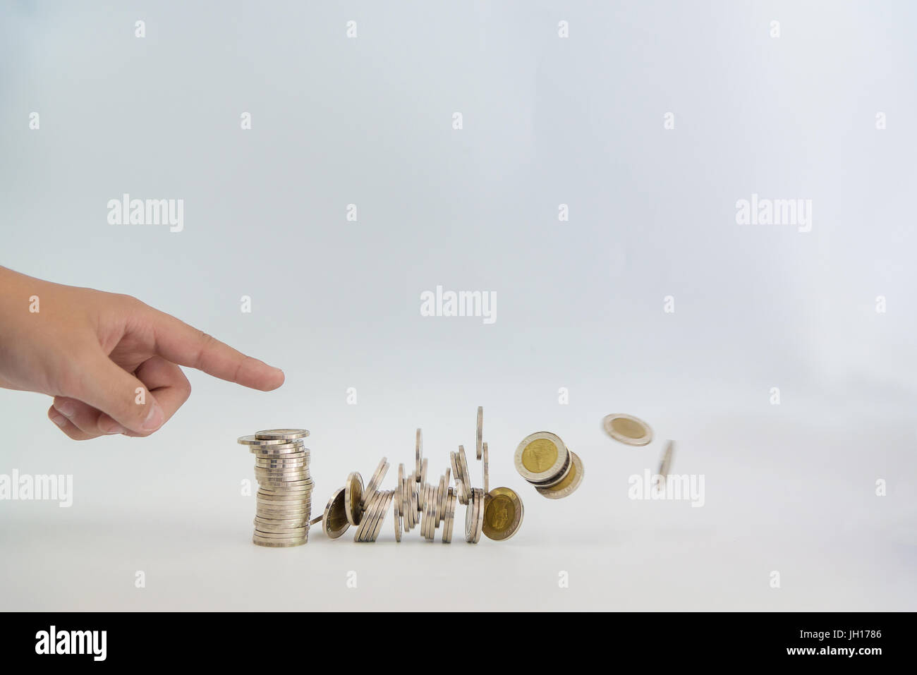 Finger pushing a pile of coins, column of coins falls , business crisis ...