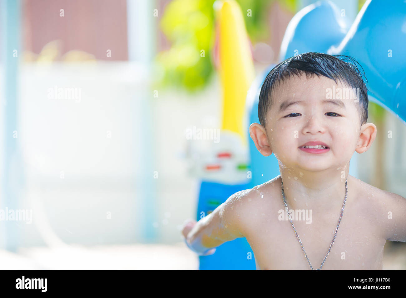 Sad Asian kid playing alone in inflatable baby pool. Boy swim and ...