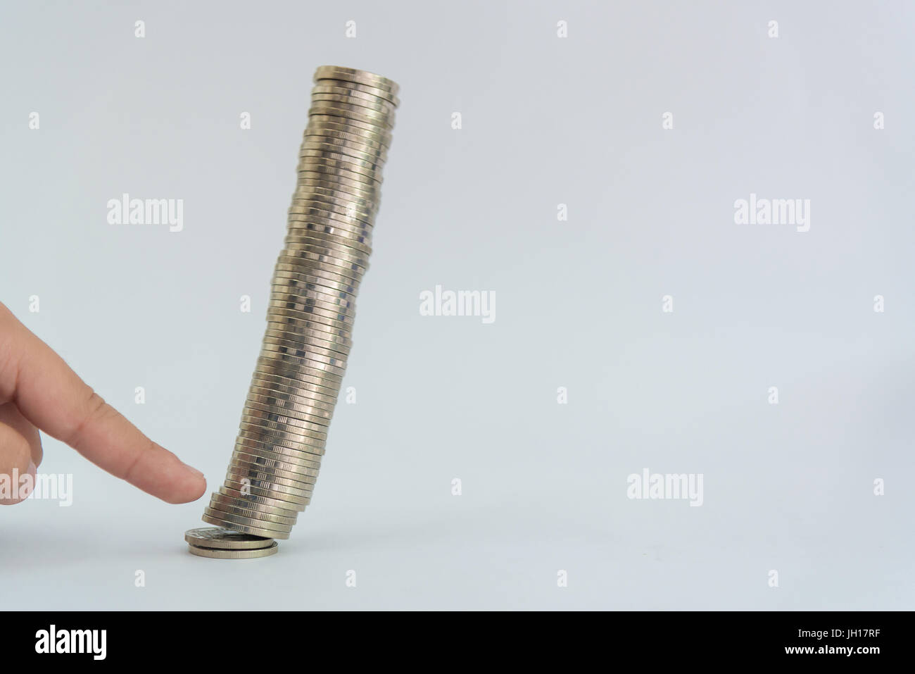Finger pushing a pile of coins, column of coins falls , business crisis ...