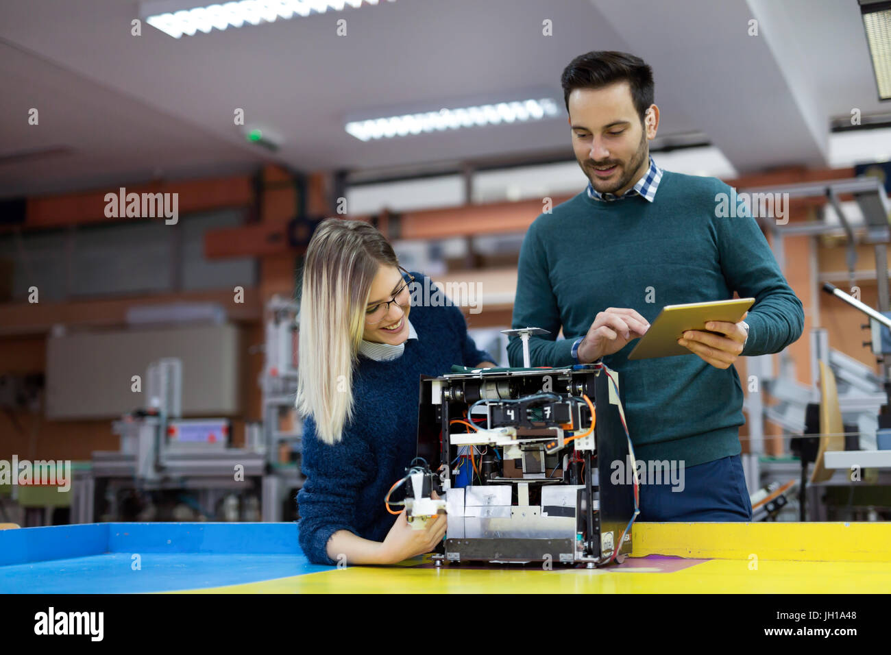 Young students of robotics preparing robot for testing Stock Photo - Alamy