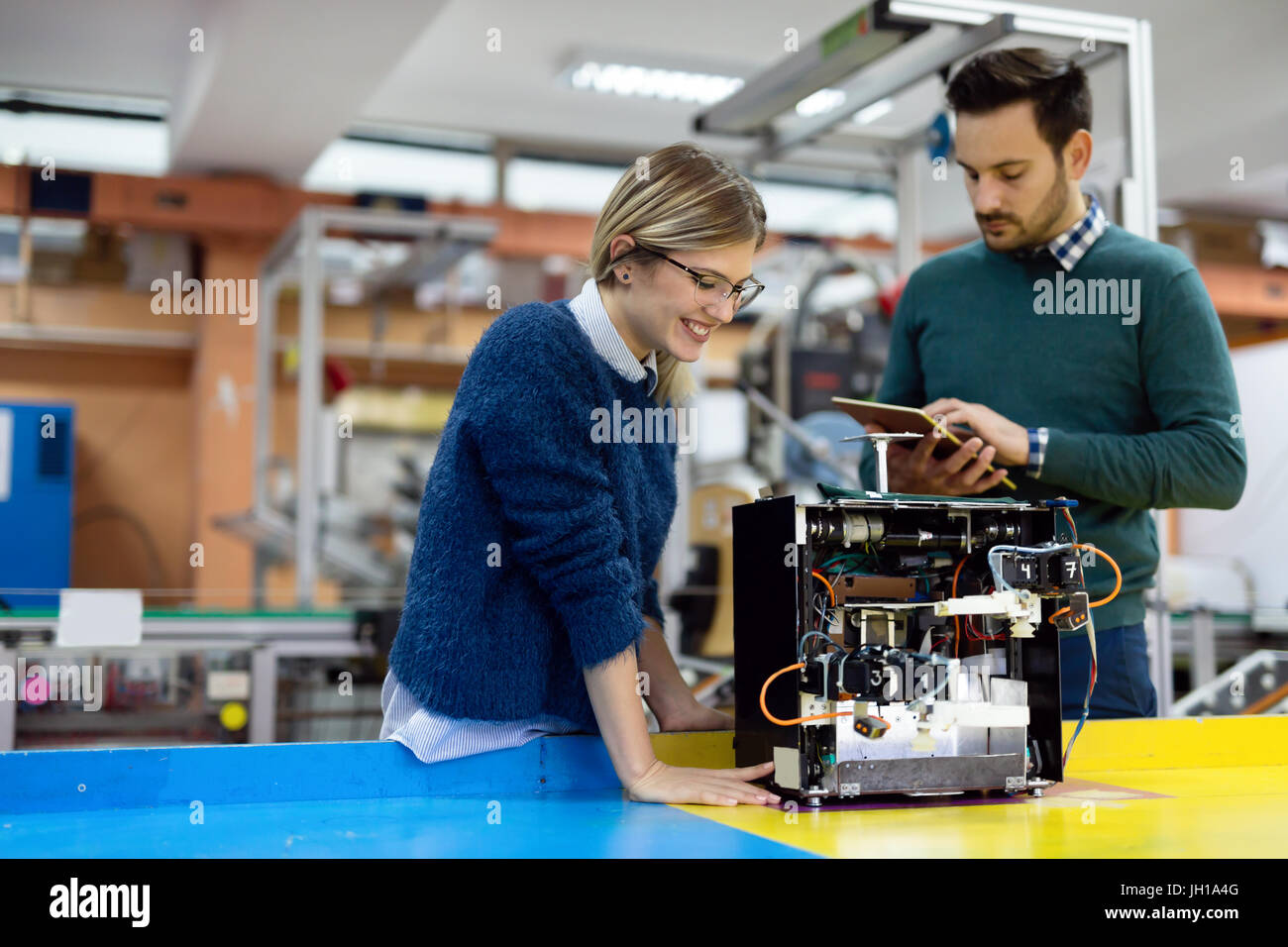 Young students of robotics preparing robot for testing Stock Photo - Alamy