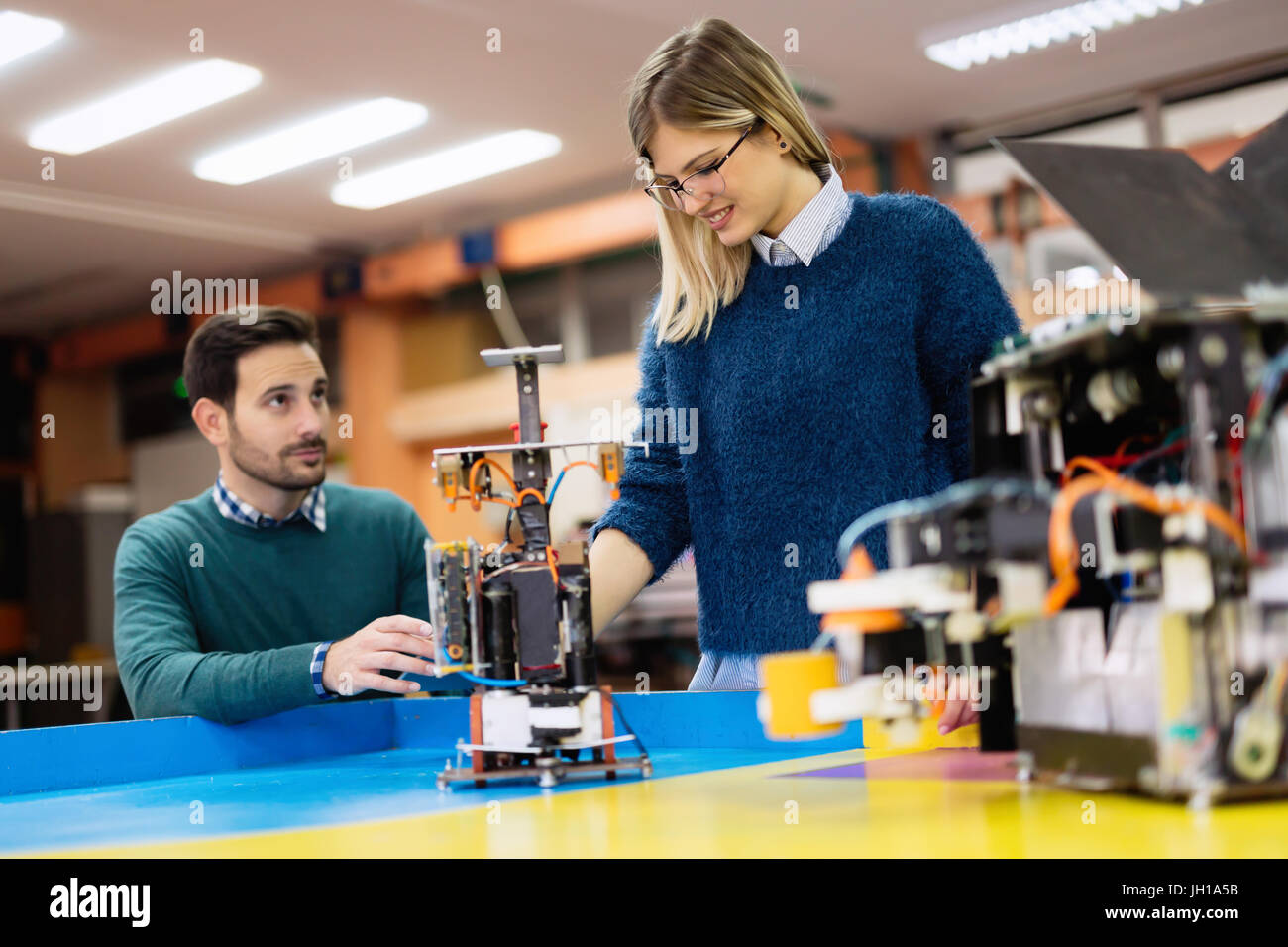 Young students of robotics preparing robot for testing Stock Photo - Alamy
