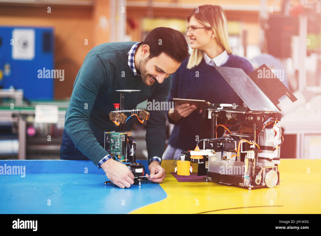 Young students of robotics preparing robot for testing Stock Photo - Alamy