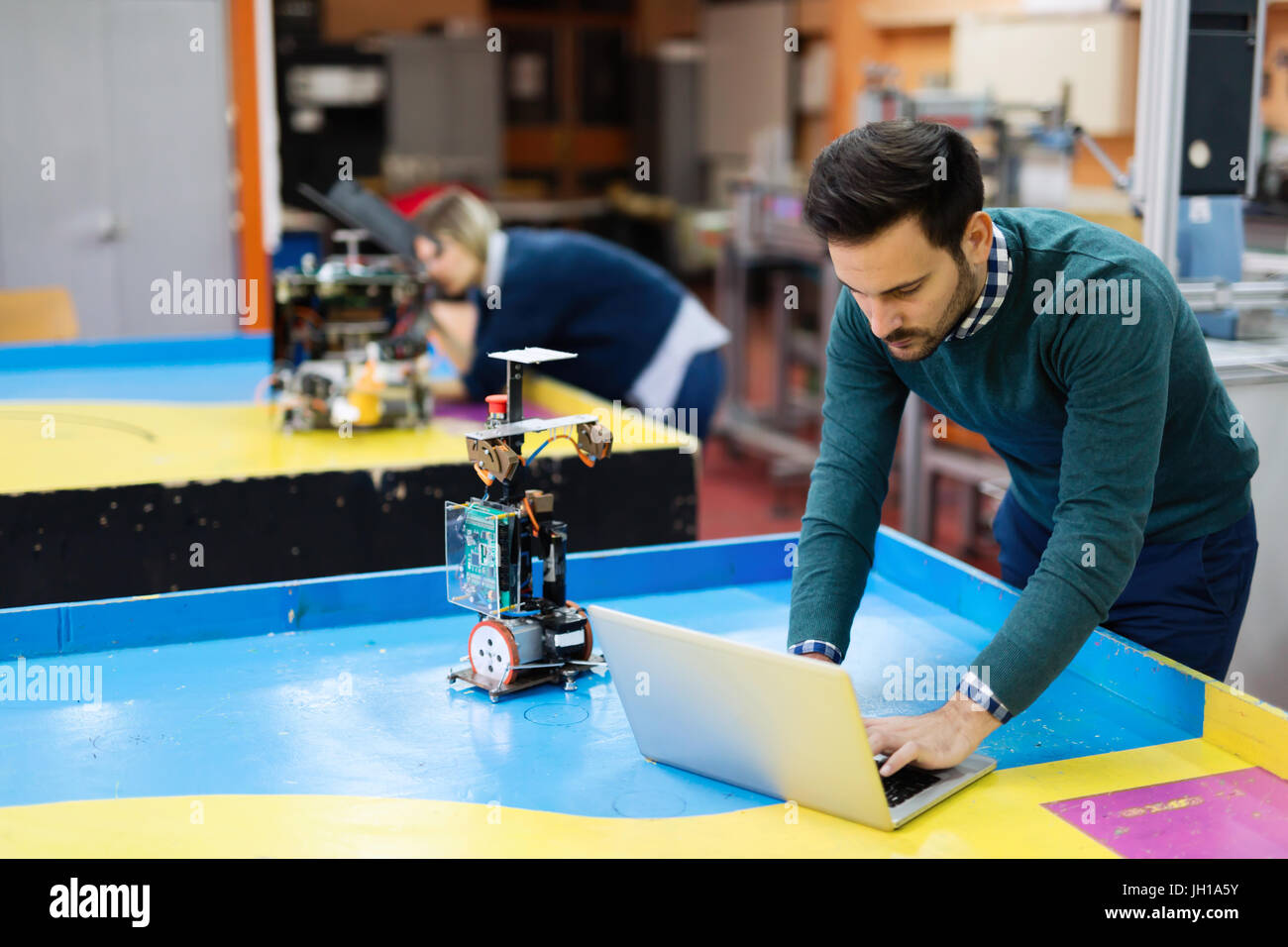 Young students of robotics preparing robot for testing Stock Photo - Alamy