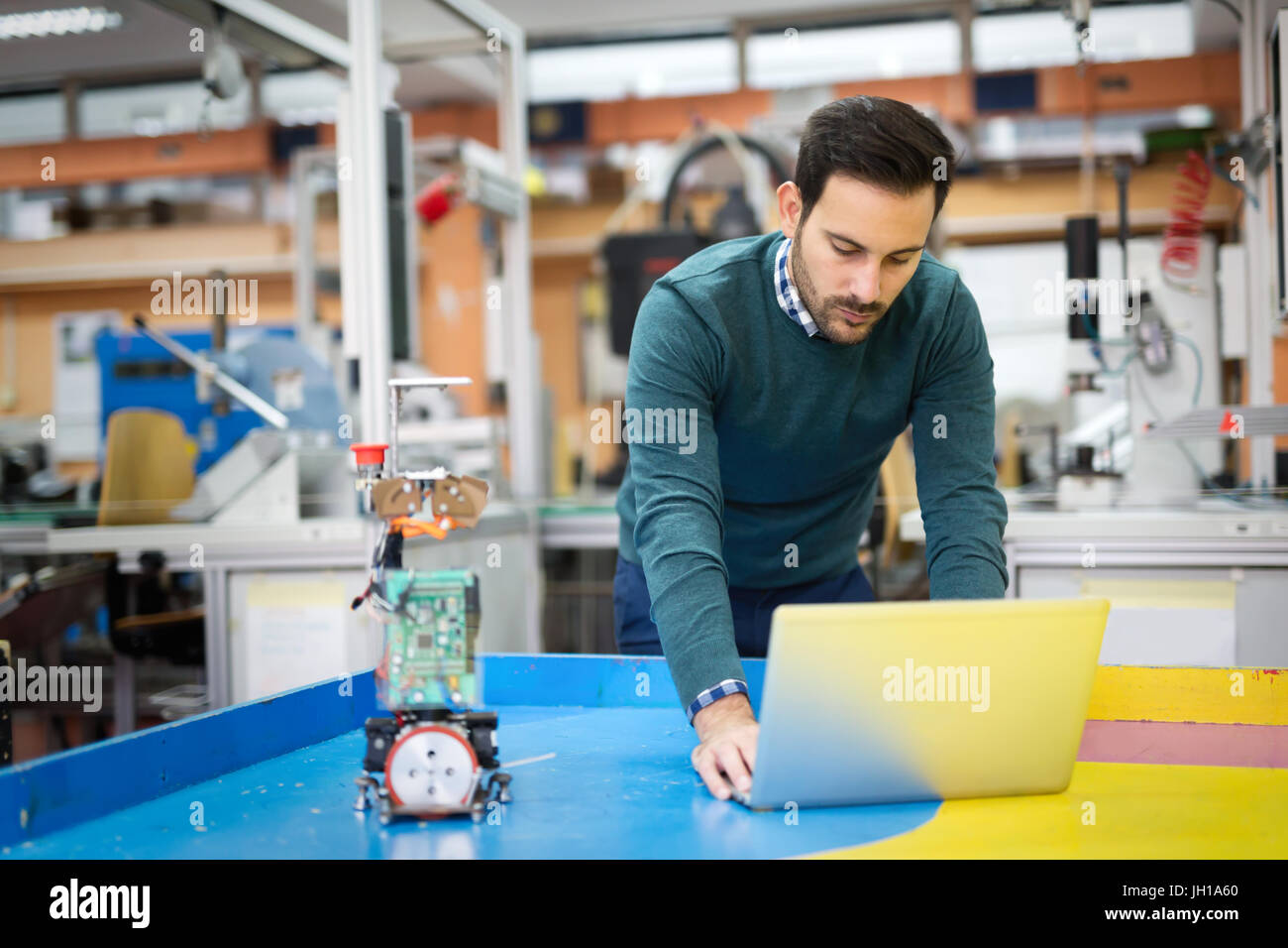 Young engineer testing his robot in workshop Stock Photo - Alamy