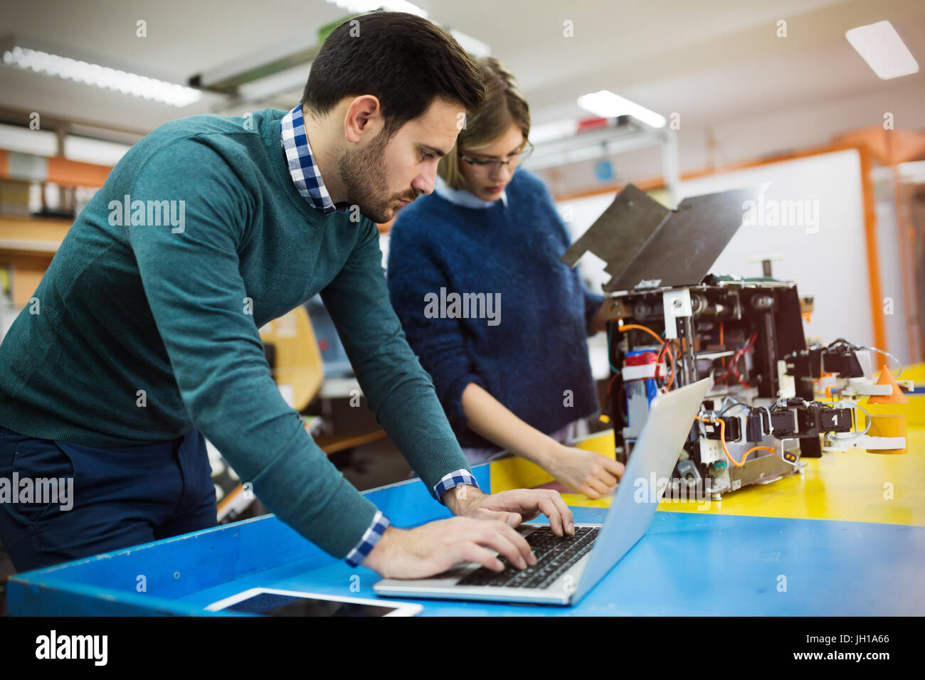 Young students of robotics preparing robot for testing Stock Photo - Alamy