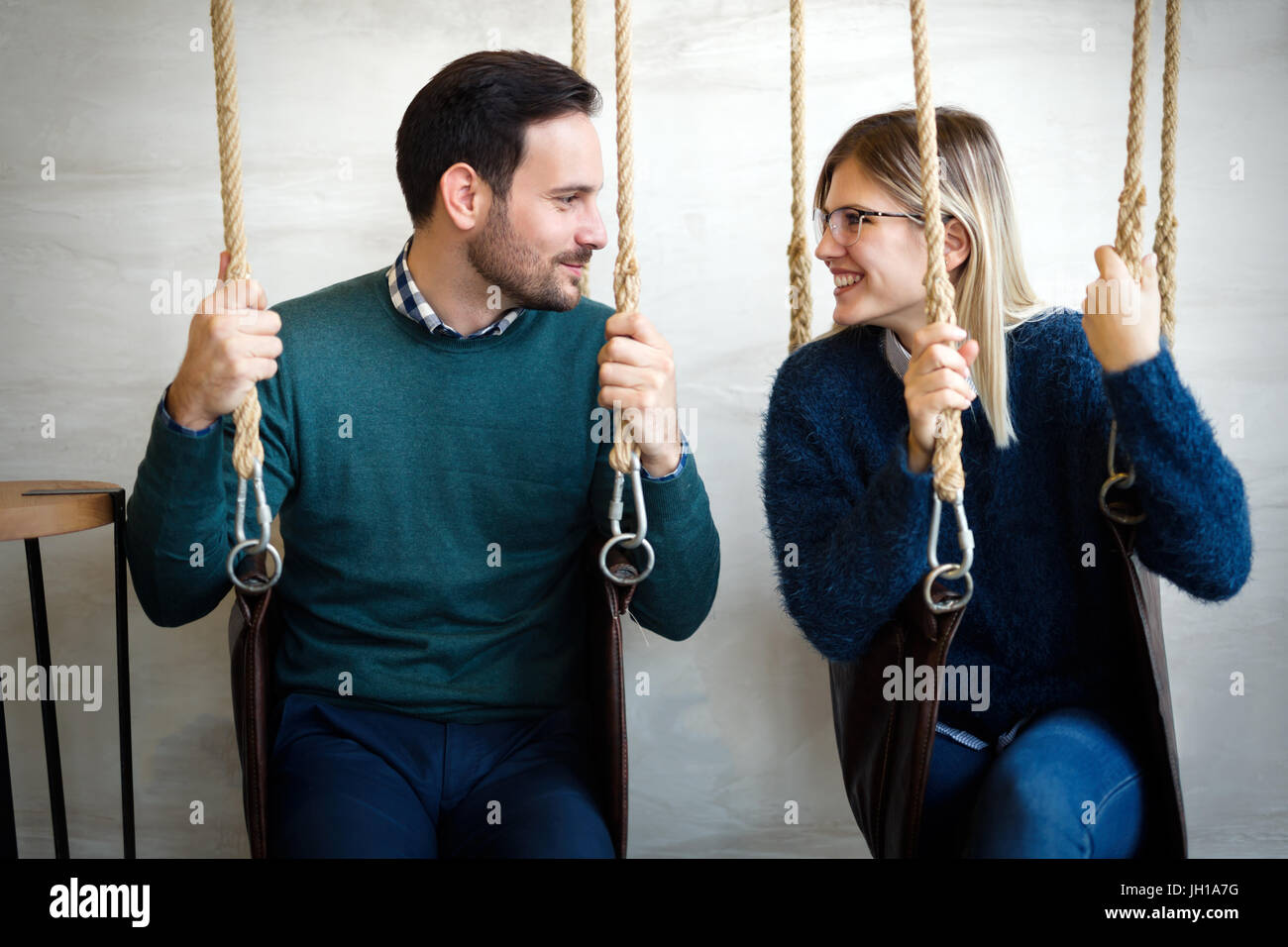 Beautiful young loving couple relaxing in swing Stock Photo - Alamy
