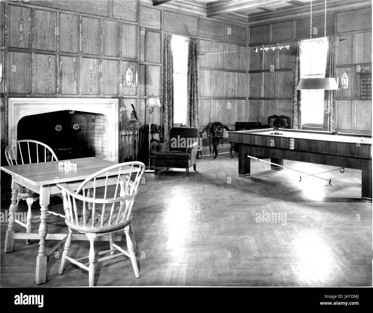 The billiard room, featuring a pool table, a fireplace, tables, and ...
