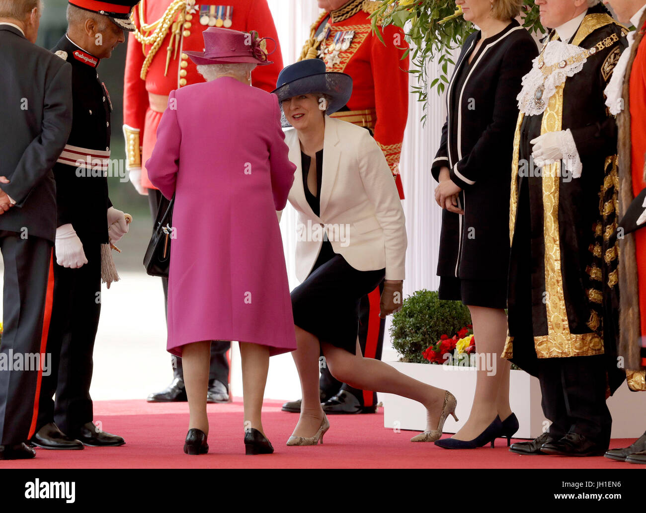 Prime Minister Theresa May curtsies as Queen Elizabeth II arrives for ...