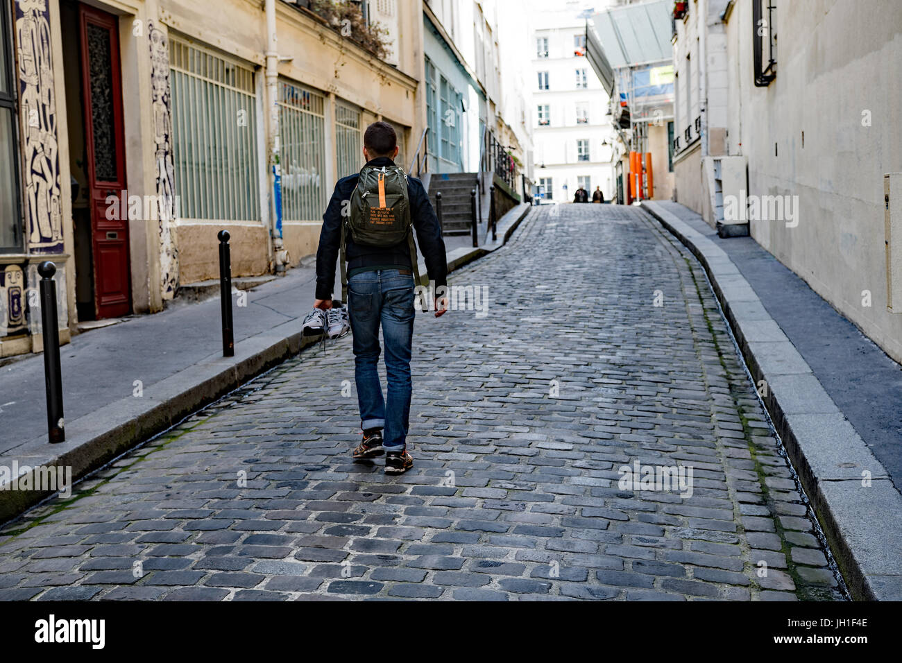 A man with a backpack walking down the street Stock Photo - Alamy