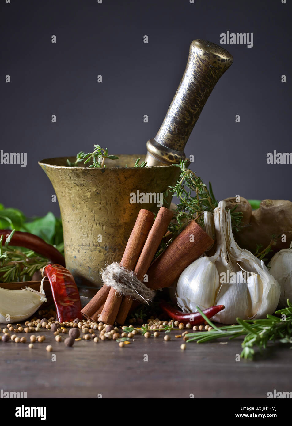 Old copper mortar with spices and herbs on kitchen table Stock Photo ...