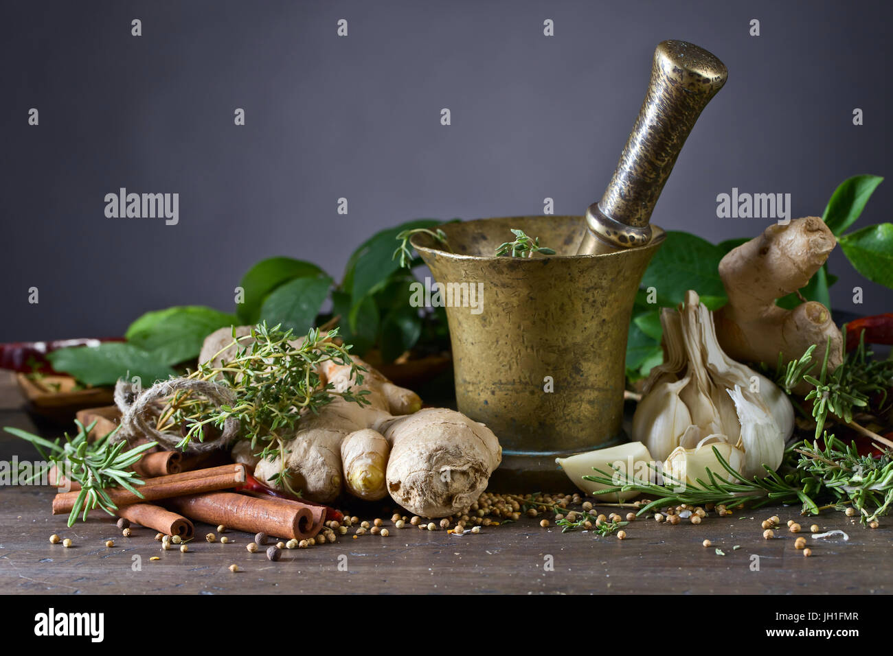 Old copper mortar with spices and herbs on kitchen table Stock Photo ...