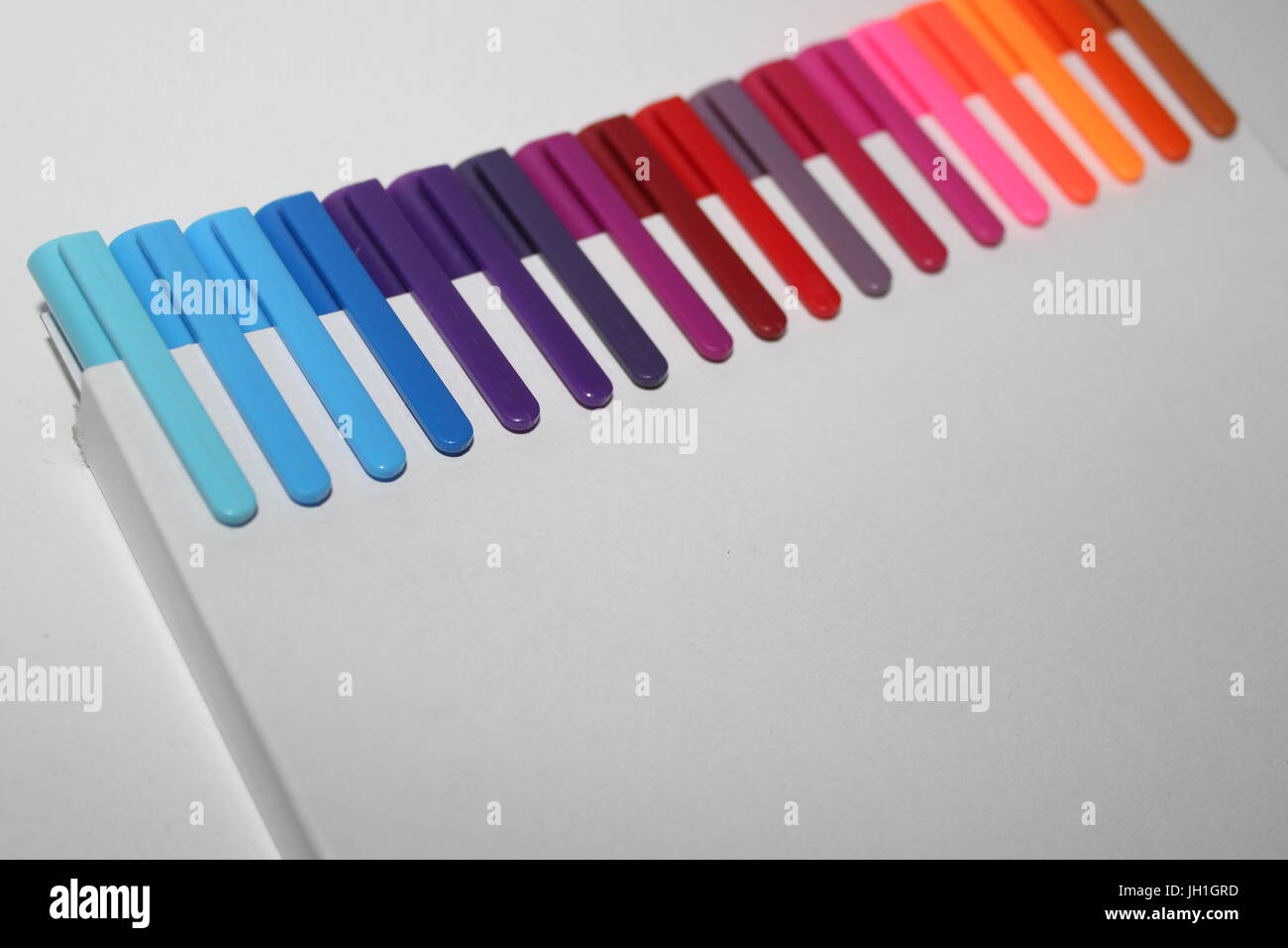 Row of pens on white background Stock Photo - Alamy
