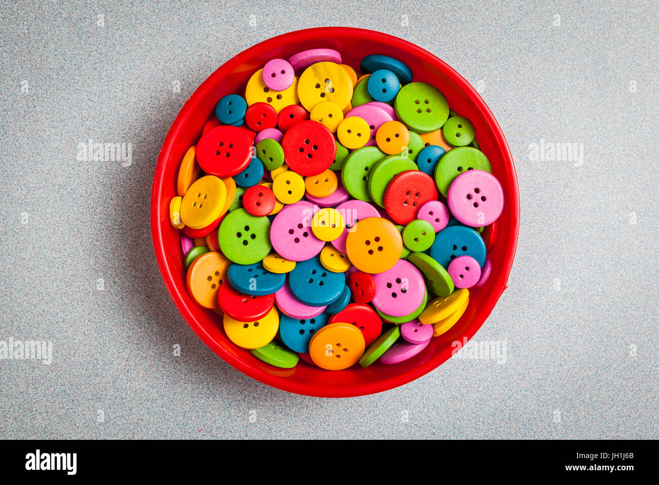 Red bowl full of colourful buttons Stock Photo - Alamy