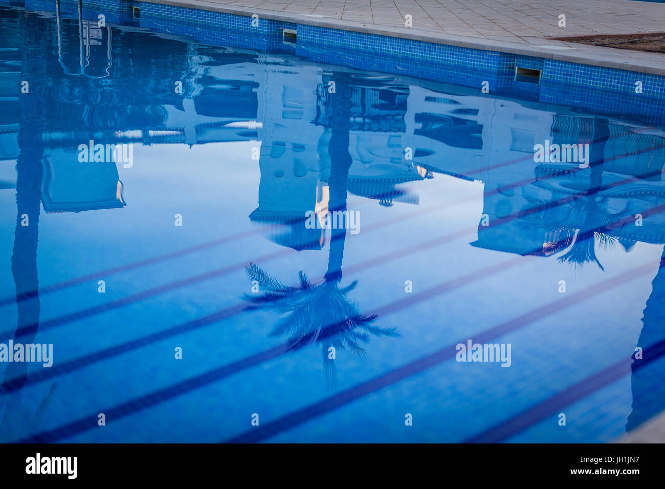Reflection of a holiday villa in a swimming pool Stock Photo - Alamy