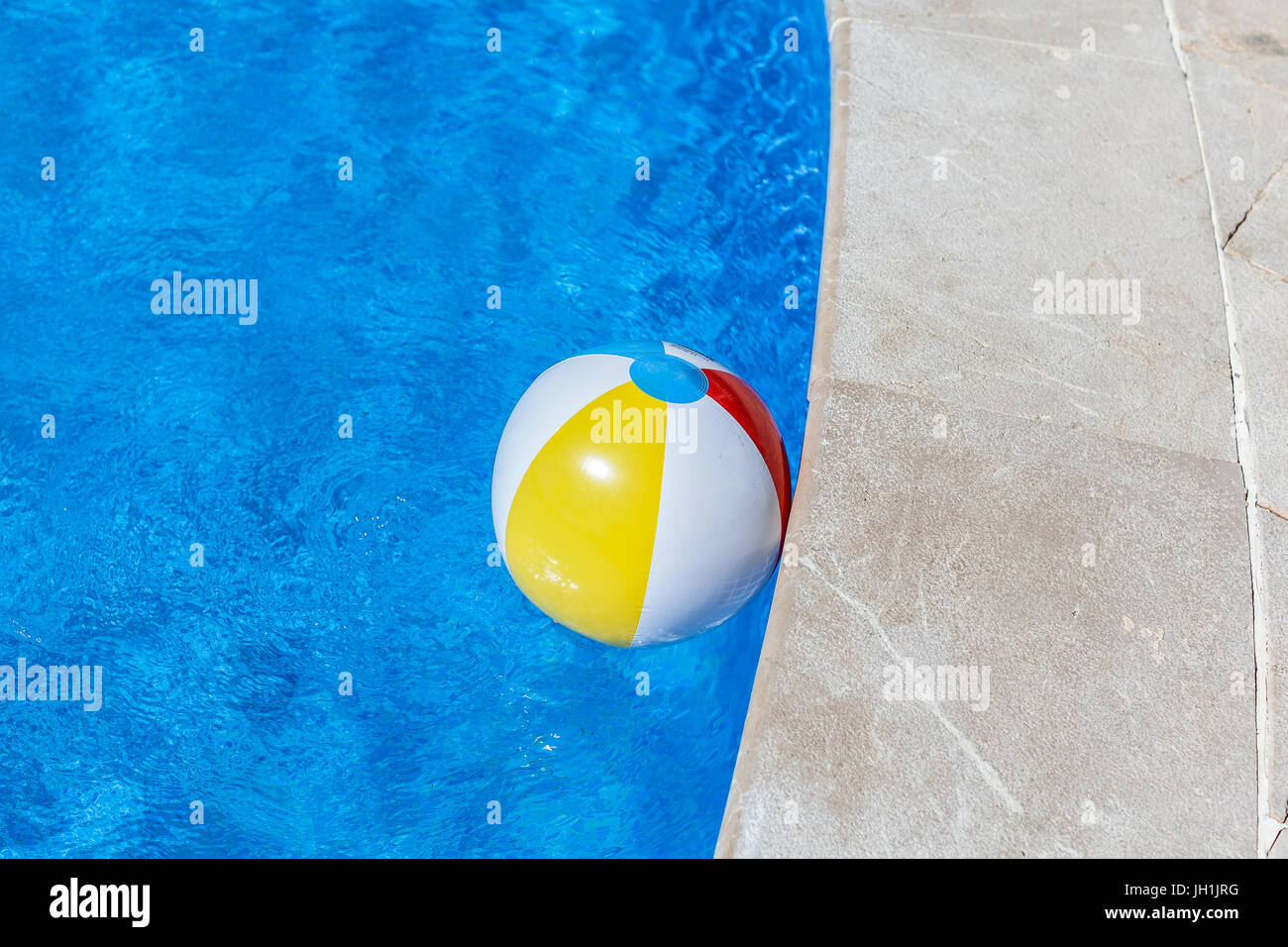 Inflatable beach ball floating in an outdoor swimming pool Stock Photo ...