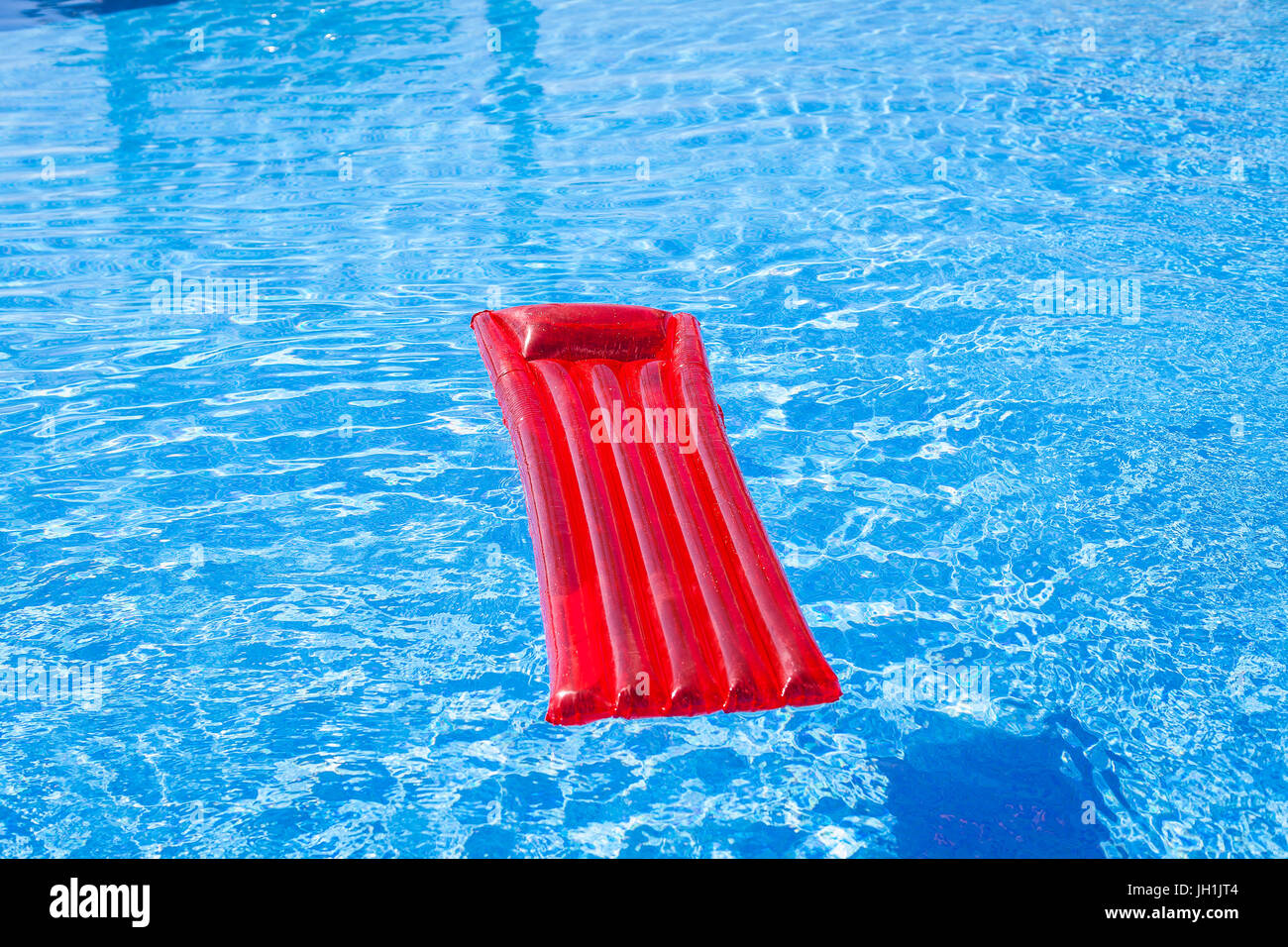 Red inflatable lilo lounger floating in a swimming pool Stock Photo - Alamy