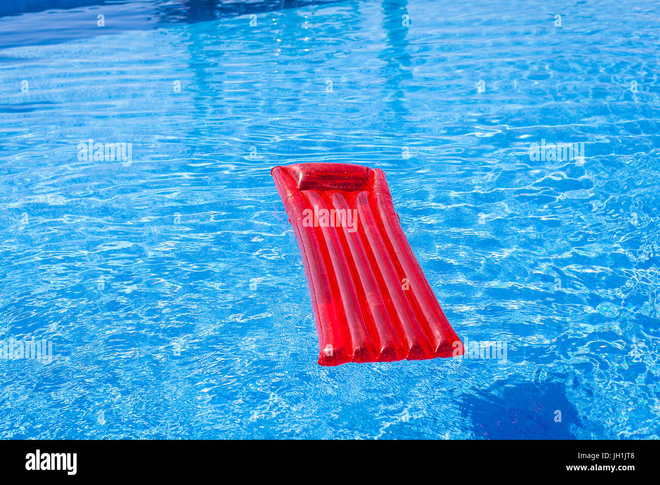 Red inflatable lilo lounger floating in a swimming pool Stock Photo - Alamy