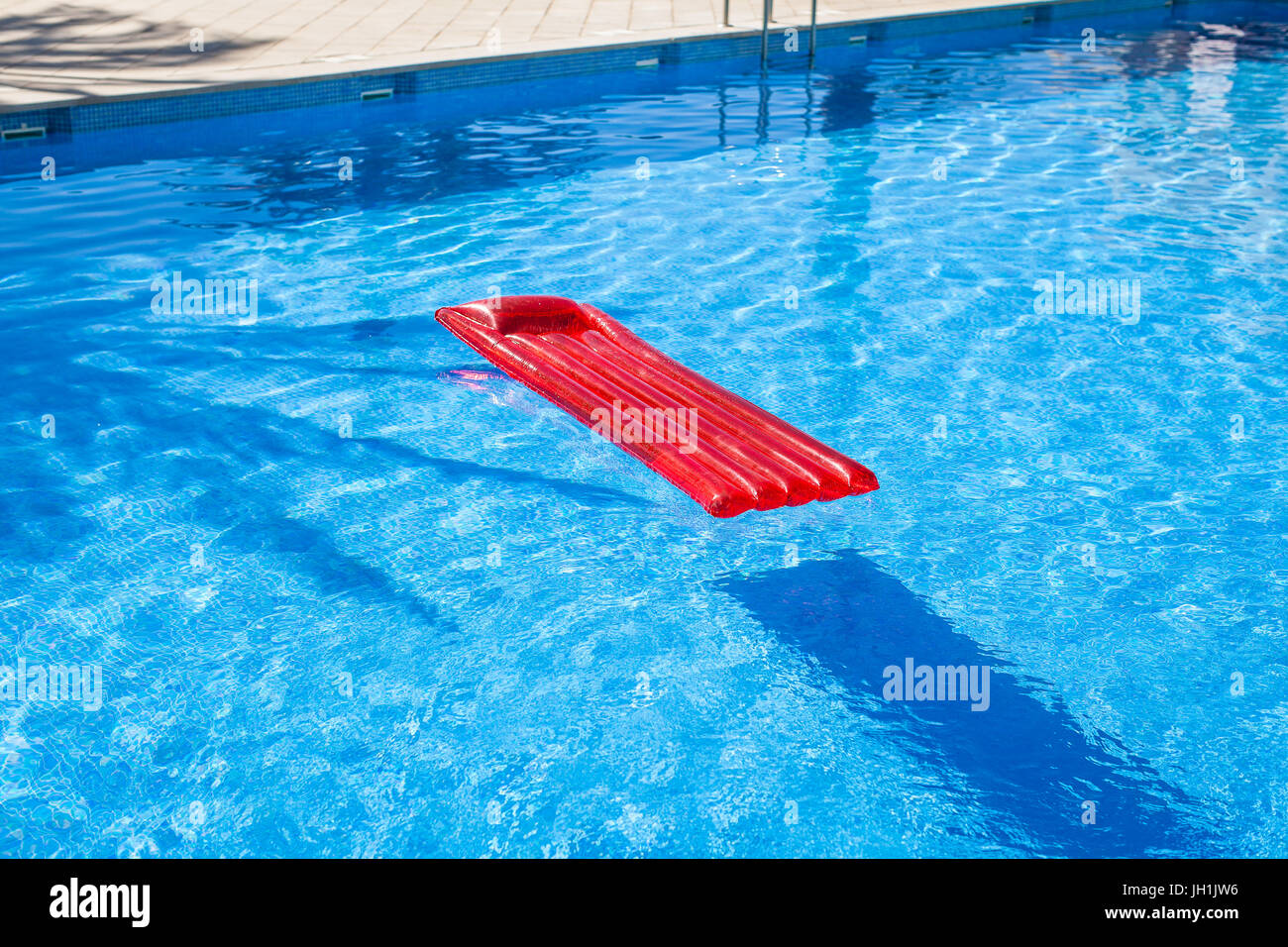 Red inflatable lilo lounger floating in a swimming pool Stock Photo - Alamy
