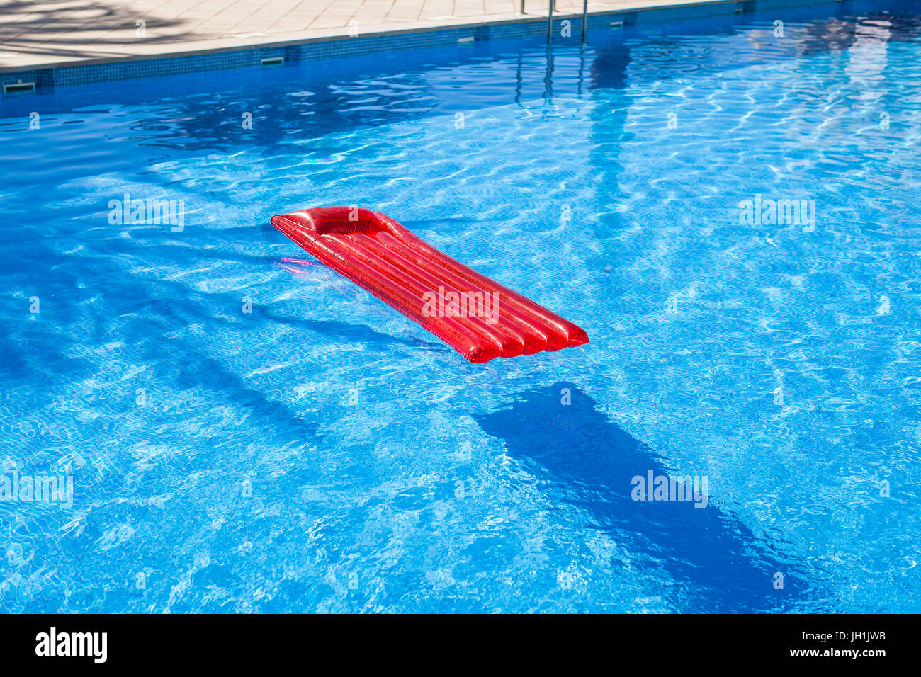 Red inflatable lilo lounger floating in a swimming pool Stock Photo - Alamy