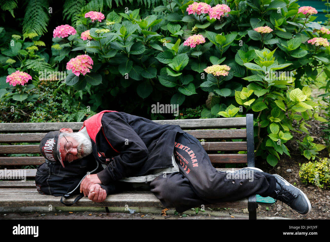 Man sleeping on a park bench. France Stock Photo - Alamy