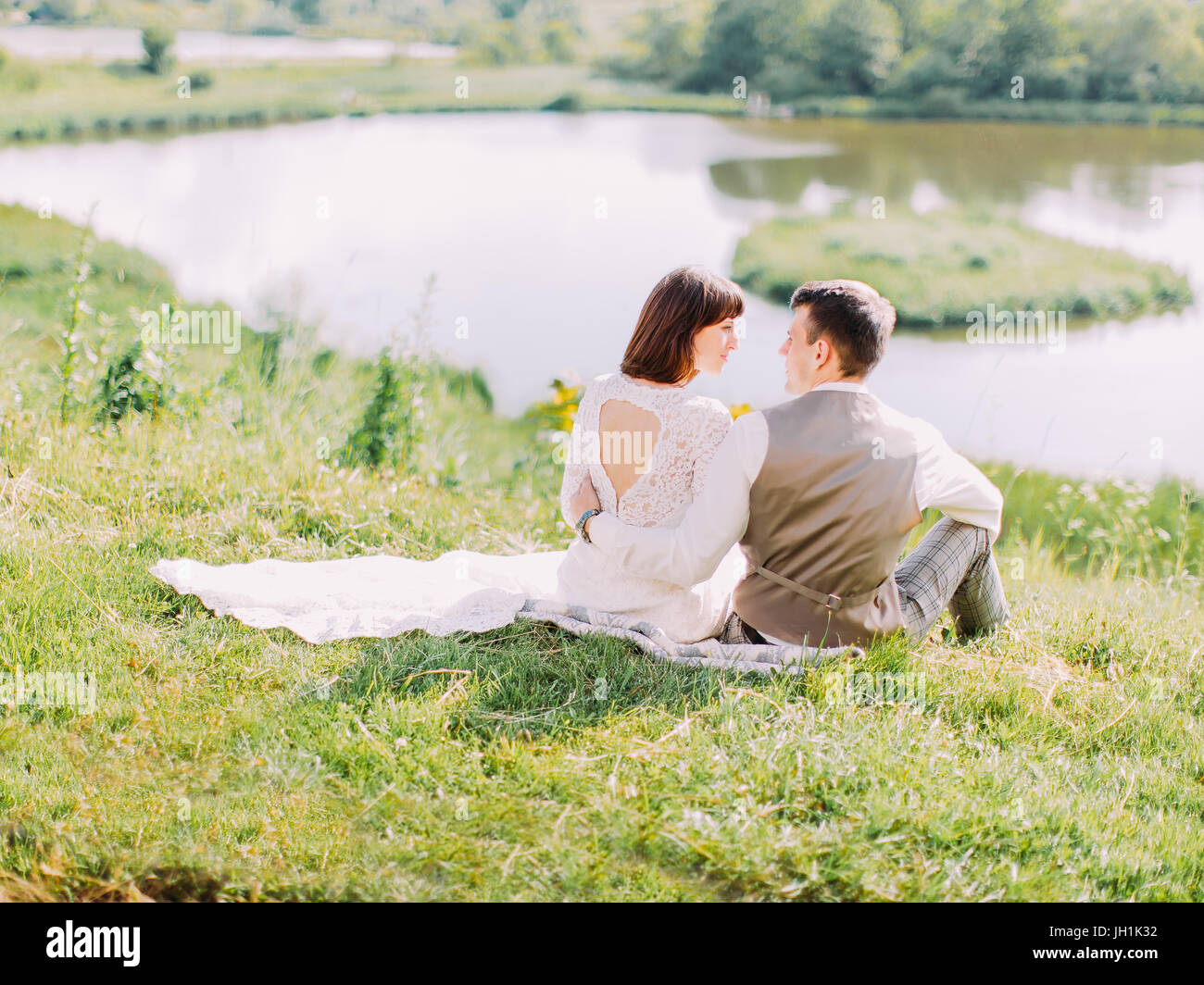 Back newlyweds hugging sitting hi-res stock photography and images - Alamy