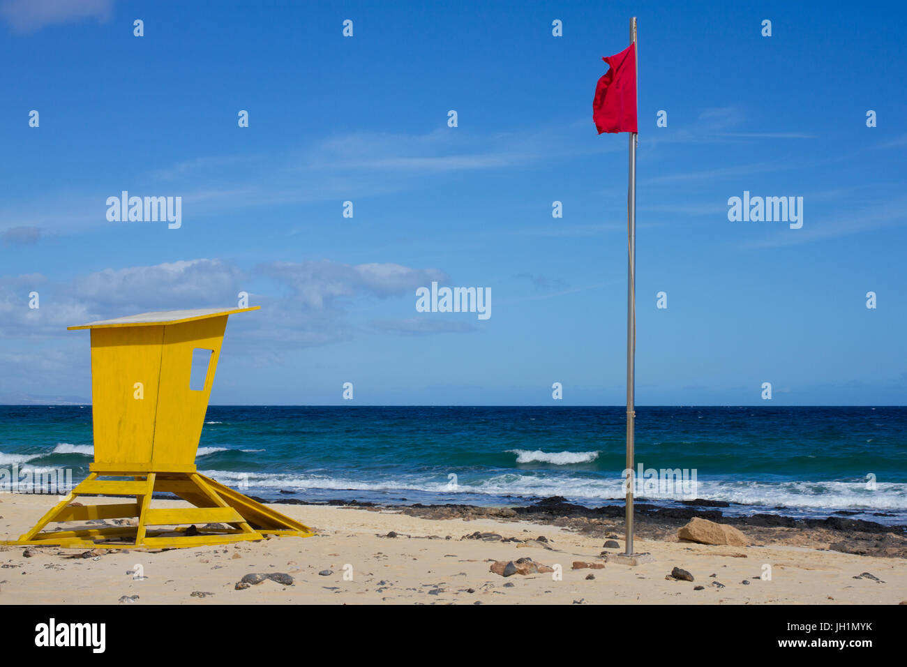 Yellow lifeguard tower. One life guard together red flag on beach ...