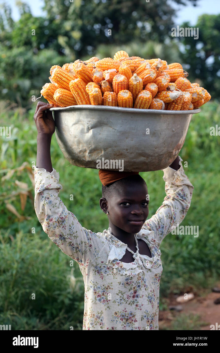 Girl carrying platter with corn on head. Togo Stock Photo - Alamy