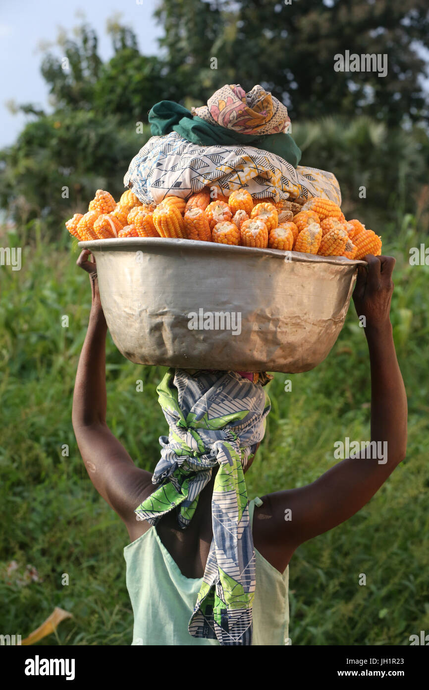 Woman carrying platter with corn on head. Togo Stock Photo - Alamy