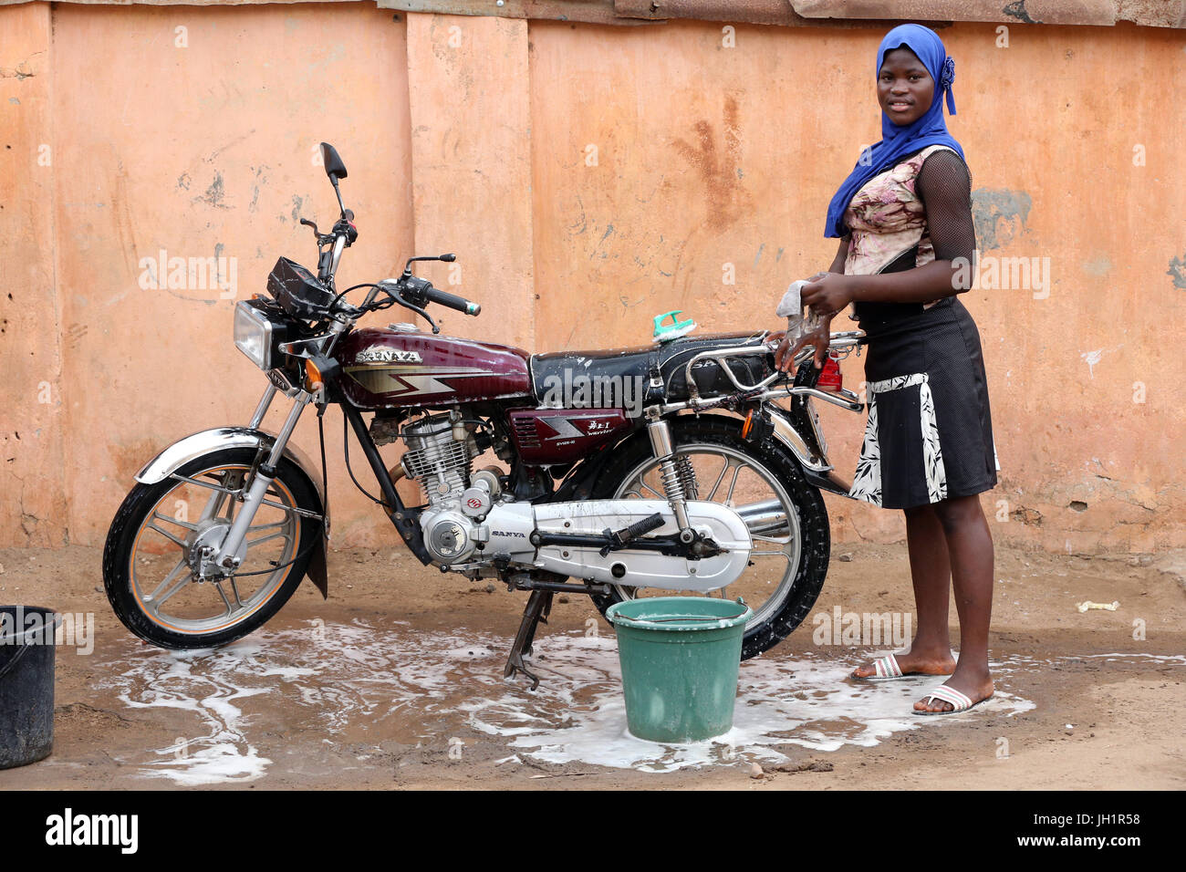 Woman washing motorbike. Lome. Togo Stock Photo - Alamy
