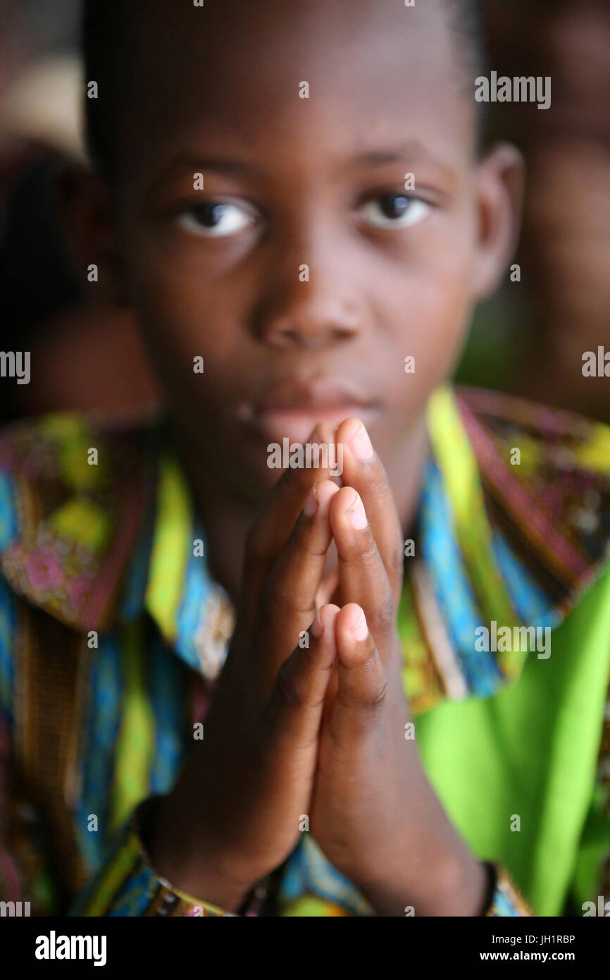 Sunday morning catholic mass. Young boy praying. Lome. Togo Stock Photo ...