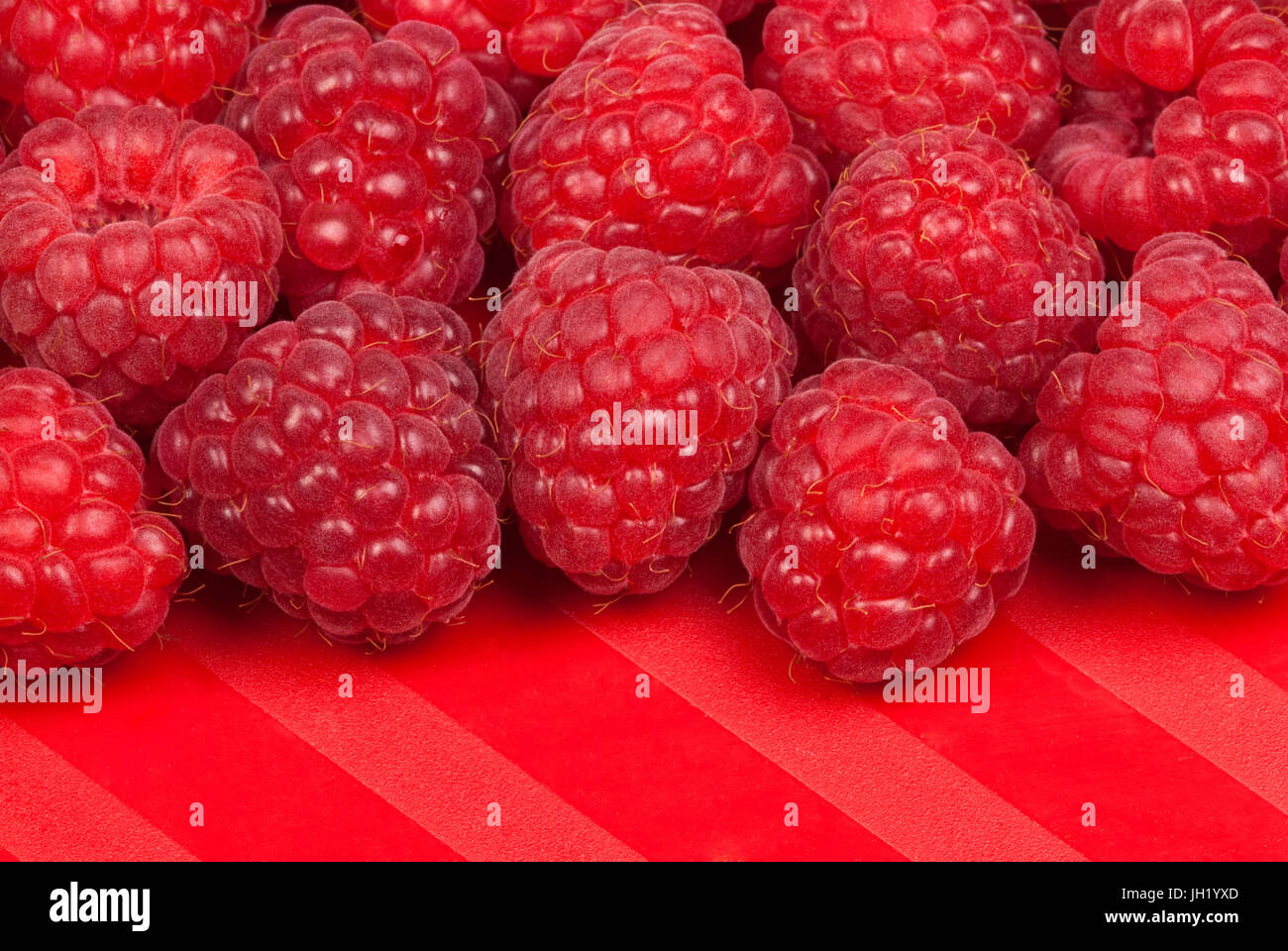 Group of raspberries on red background. Studio shoot Stock Photo - Alamy