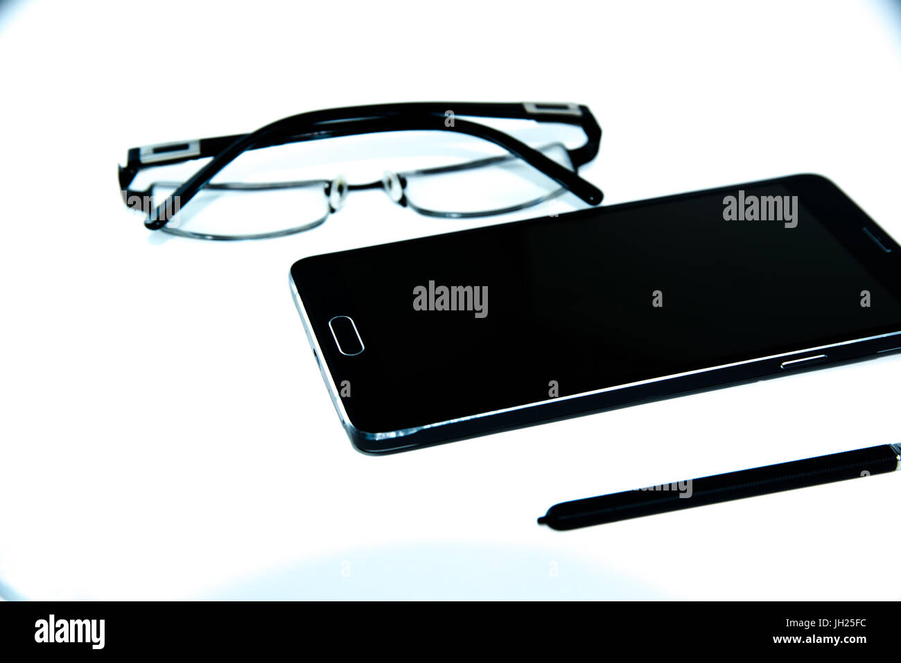 Big black smart phone with smart pen and black eye glasses isolated on ...