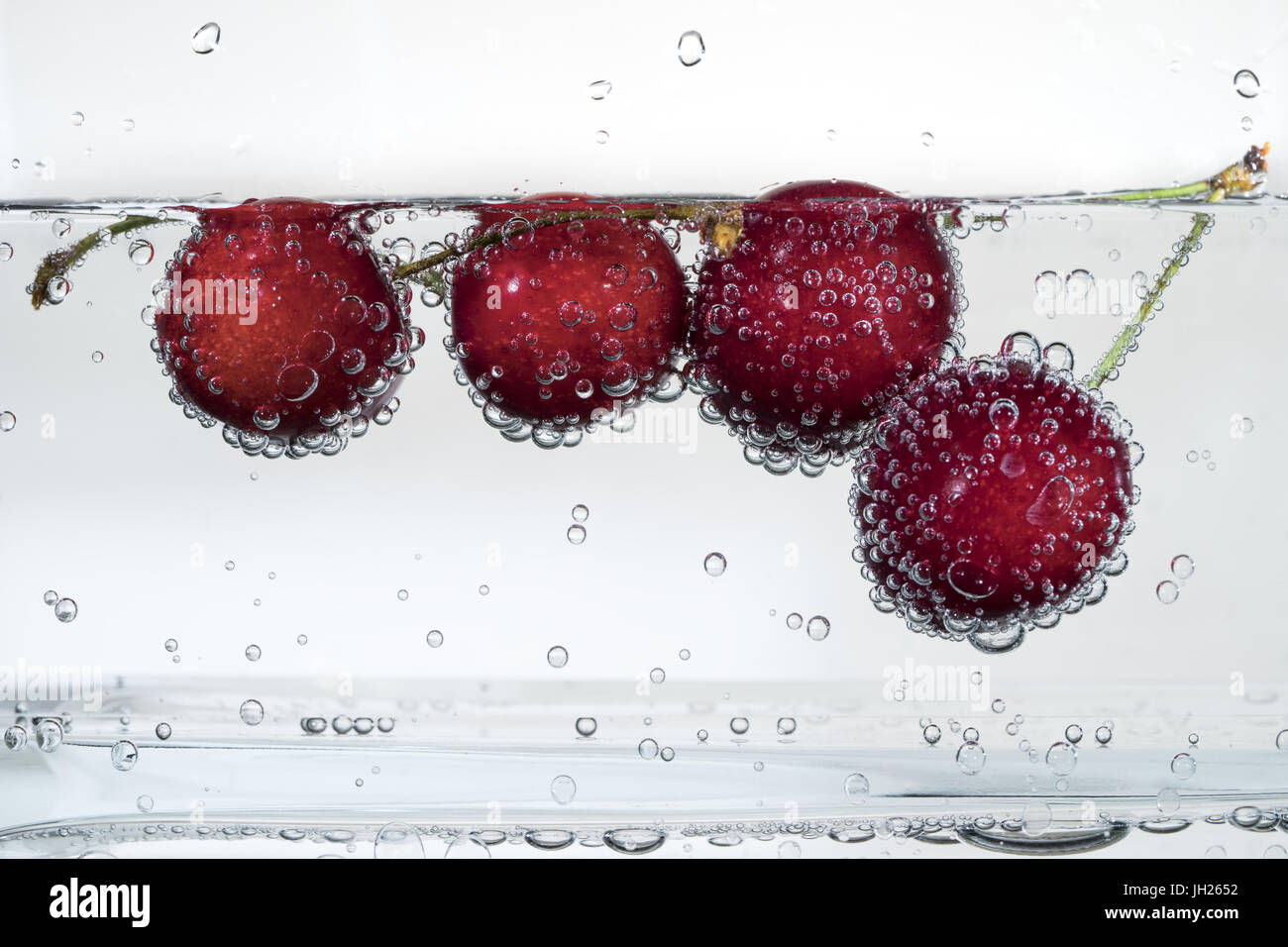 sweet cherries and bubbles in water, close up Stock Photo - Alamy