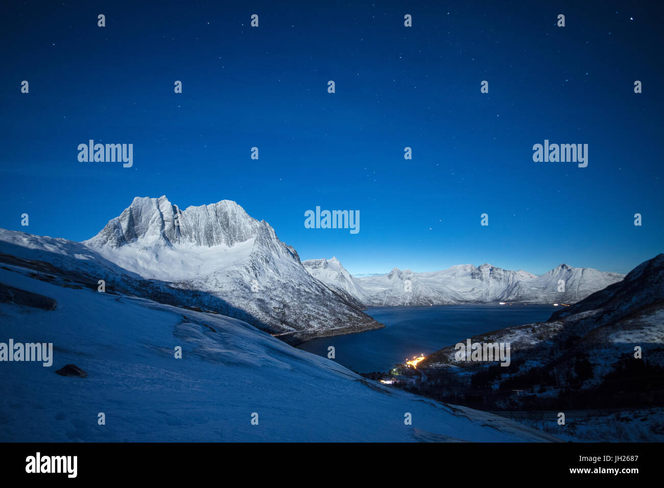 Stars of the polar night on the Senjahopen peak and frozen sea, Senja ...