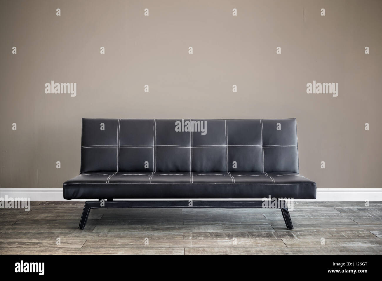 Front view of black leather sofa in interior Stock Photo - Alamy