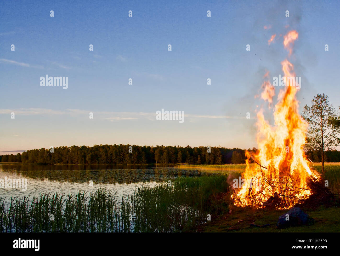 A midsummer bonfire by a lake Stock Photo - Alamy