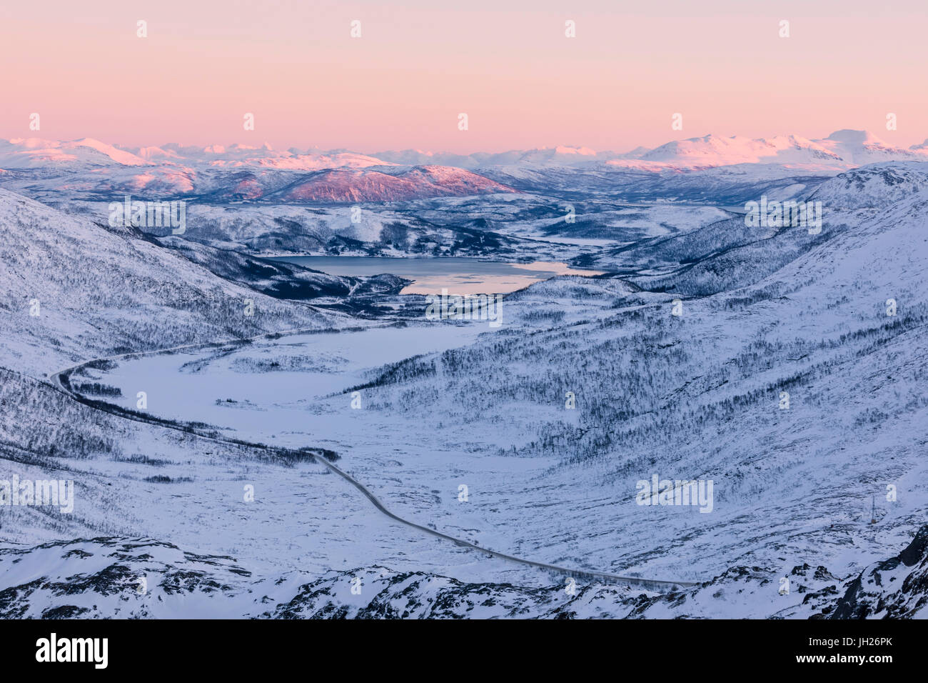 Pink sky at sunset on the snowy landscape and frozen sea surrounding ...